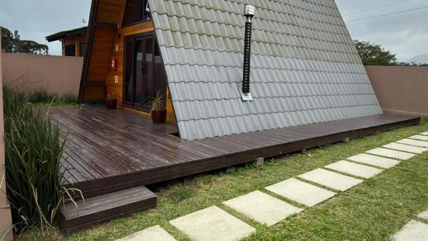 Uma casa moderna com telhado inclinado e um deck de madeira.