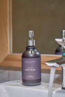 Um frasco de sabonete líquido do Hotel Amaya Saigon Boutique em uma pia de banheiro.