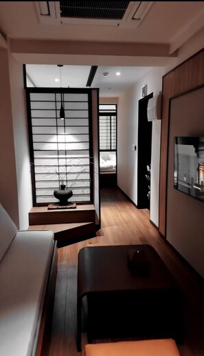 Um interior moderno com um sofá, uma mesa e um painel decorativo com uma luminária suspensa.