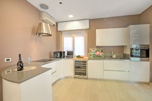 Apartamento Familiar, 3 quartos (Residenza Albachiara) | Cozinha privada | Um frigorífico, um micro-ondas, um forno, uma placa de cozinha