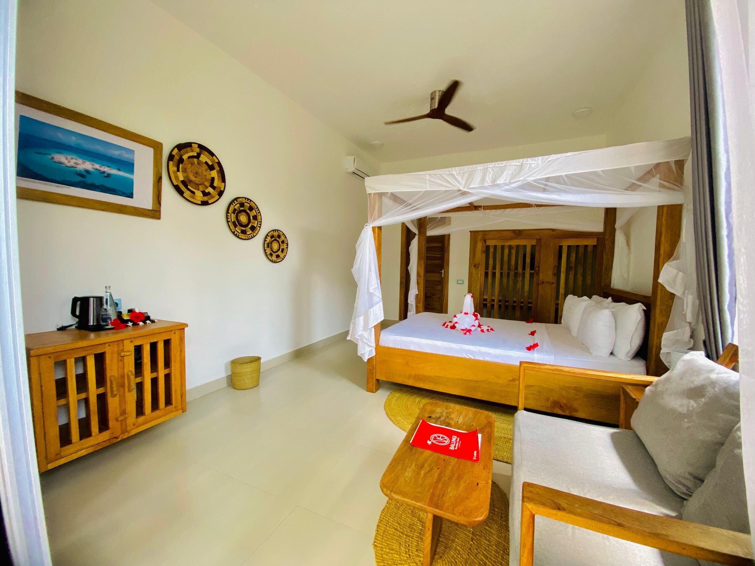 Quarto com uma cama, uma mesinha, um armário e um ventilador de teto.