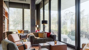 Uma sala de estar moderna com grandes janelas, lareira e diversas opções de assentos.