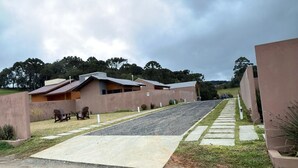 Um edifício moderno com vários quartos, um caminho pavimentado e área de estar ao ar livre.