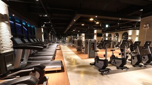 Uma academia com esteiras, elípticos e aparelhos de musculação.