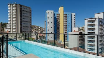Piscina no terraço com vista desobstruída para edifícios altos ao redor.