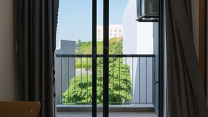 Varanda com vista para um edifício e vegetação.