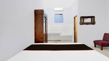 Quarto com cama, guarda-roupa de madeira, espelho e uma cadeira vermelha.
