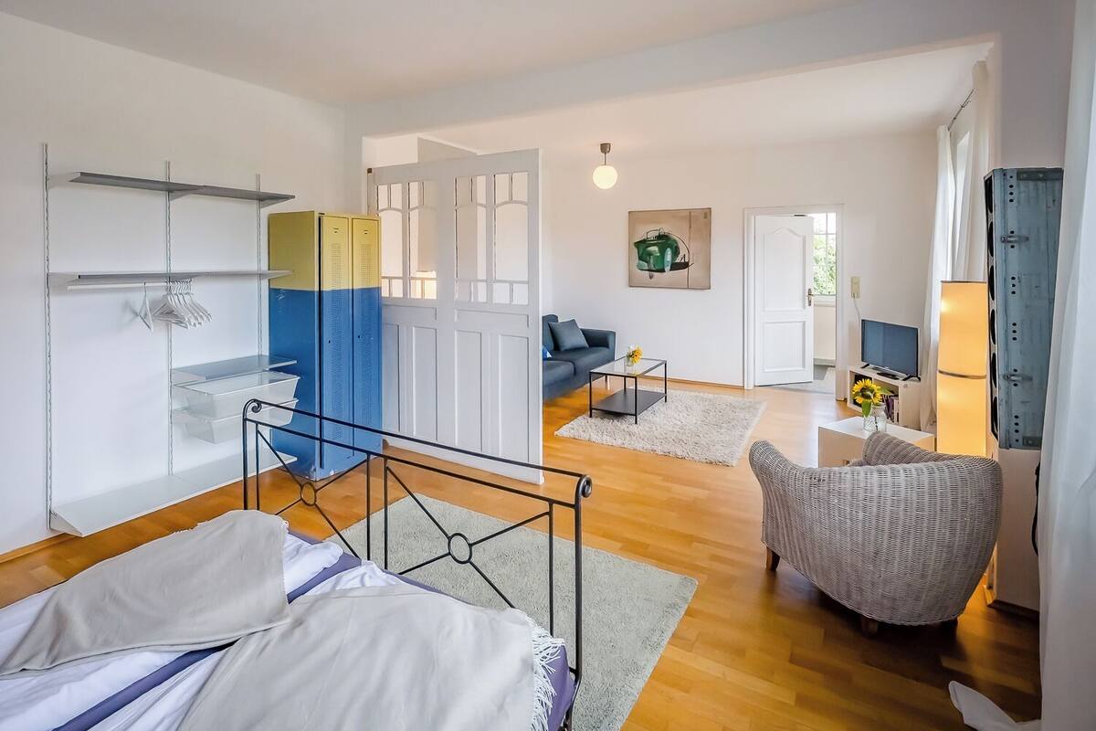 Um quarto moderno com cama, escrivaninha, cadeira e armário.