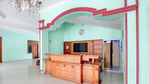 Um quarto espaçoso com um amplo centro de entretenimento de madeira, uma televisão e um relógio na parede.