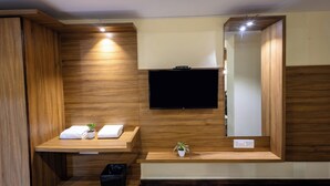 Casa de banho moderna com painéis de madeira, televisão montada e espelho.