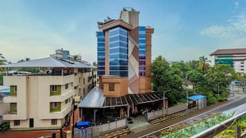 Um edifício com vários andares e design moderno, com uma combinação de fachadas de vidro e tijolo.