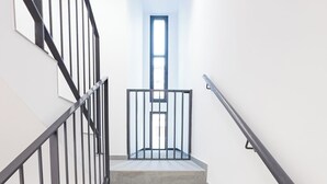 Escada com grades de metal e vista para uma porta no topo.