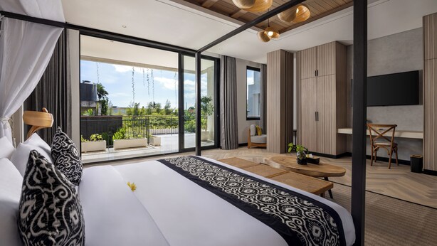 Quarto de hotel moderno com uma cama grande, varanda com vista, área de refeições e televisão.