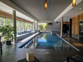 Um hall de hotel com piscina, área de estar e grandes janelas.