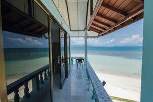 Varanda coberta com vista para a praia e o oceano.