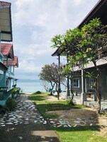 Uma trilha leva a um edifício com vista para o mar.