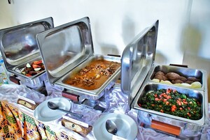 Buffet com diversos pratos, incluindo carne, batatas e vegetais.
