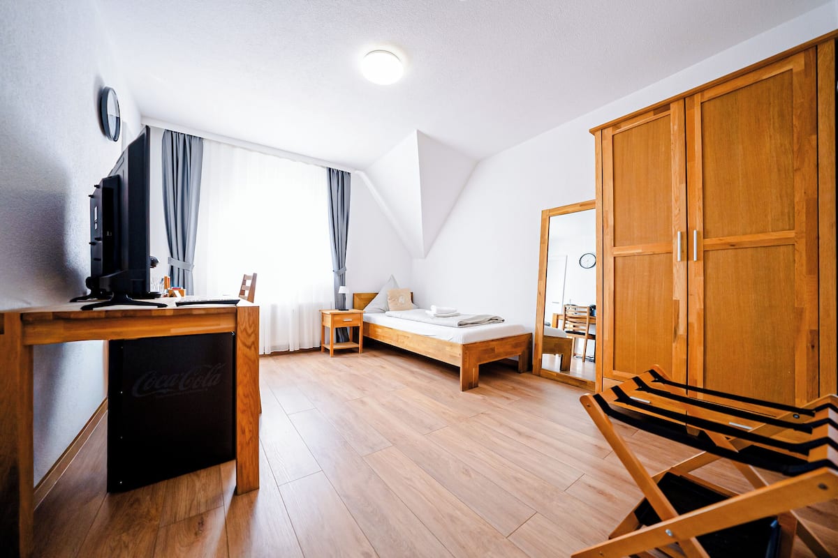 Quarto moderno com cama, escrivaninha, guarda-roupa e janela com cortinas.