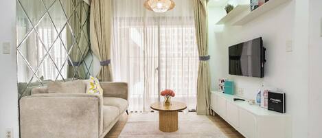 Apartamento Deluxe, 2 quartos, varanda, Vista para a cidade | Sala de estar | Televisor de ecrã plano de 55 polegadas com canais por cabo, Netflix