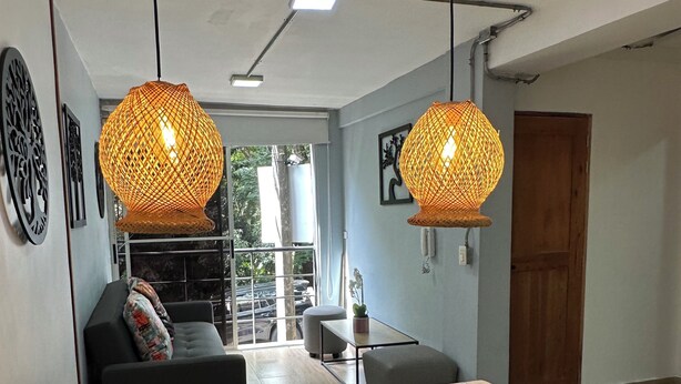 Cozinha moderna com ilha central, luminárias pendentes e vista para o exterior.