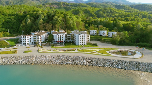 Resort com vários edifícios brancos, um pátio central e paisagem verde exuberante ao redor.