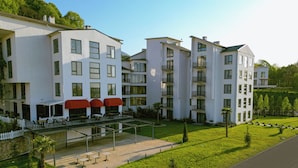 Um hotel moderno de vários andares, com área de estar externa e um gramado bem cuidado.