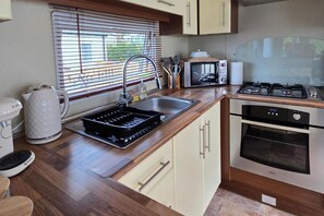 Um frigorífico, um micro-ondas, um forno, uma placa de cozinha 