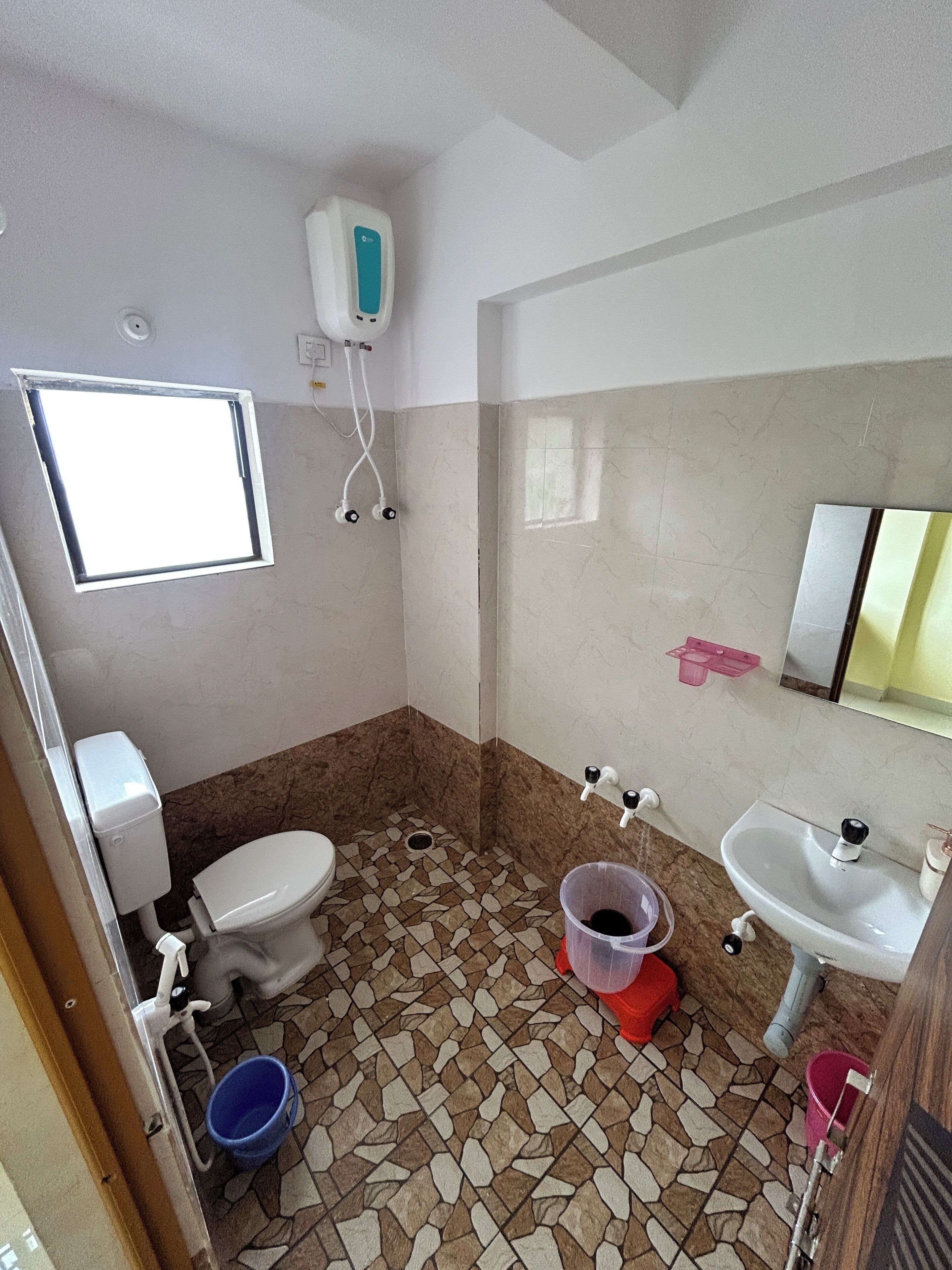 Casa de banho com sanita, lavatório e janela.