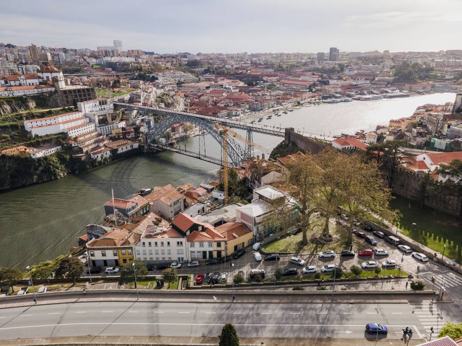 Paisagem urbana com uma ponte imponente, edifícios históricos e um rio.