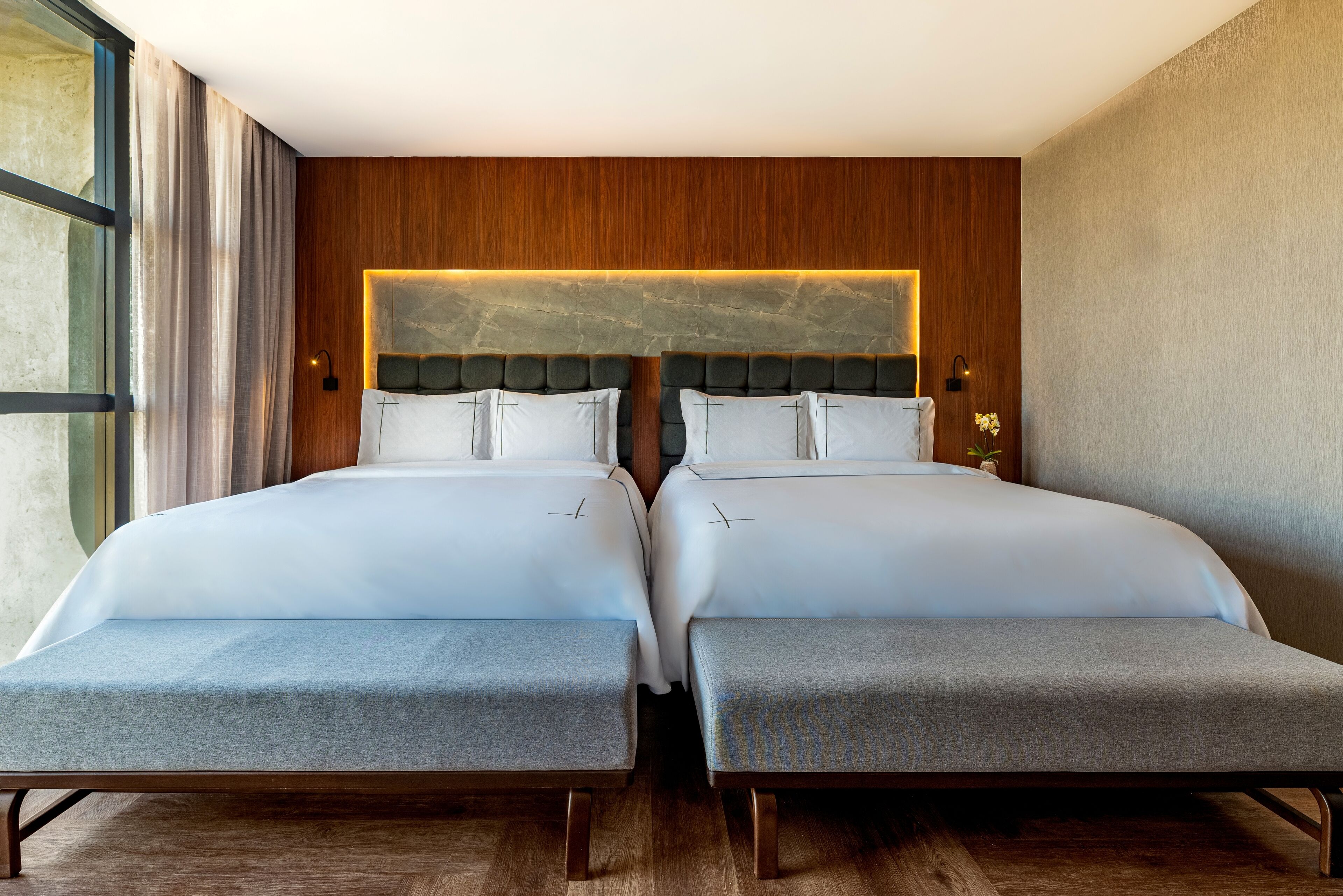 Uma cama de casal com cabeceira de madeira e mesa de cabeceira.