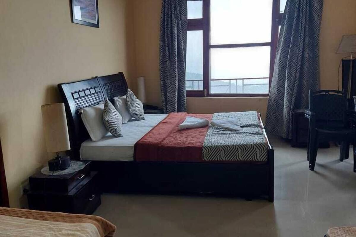 Quarto com cama, escrivaninha e cadeira.