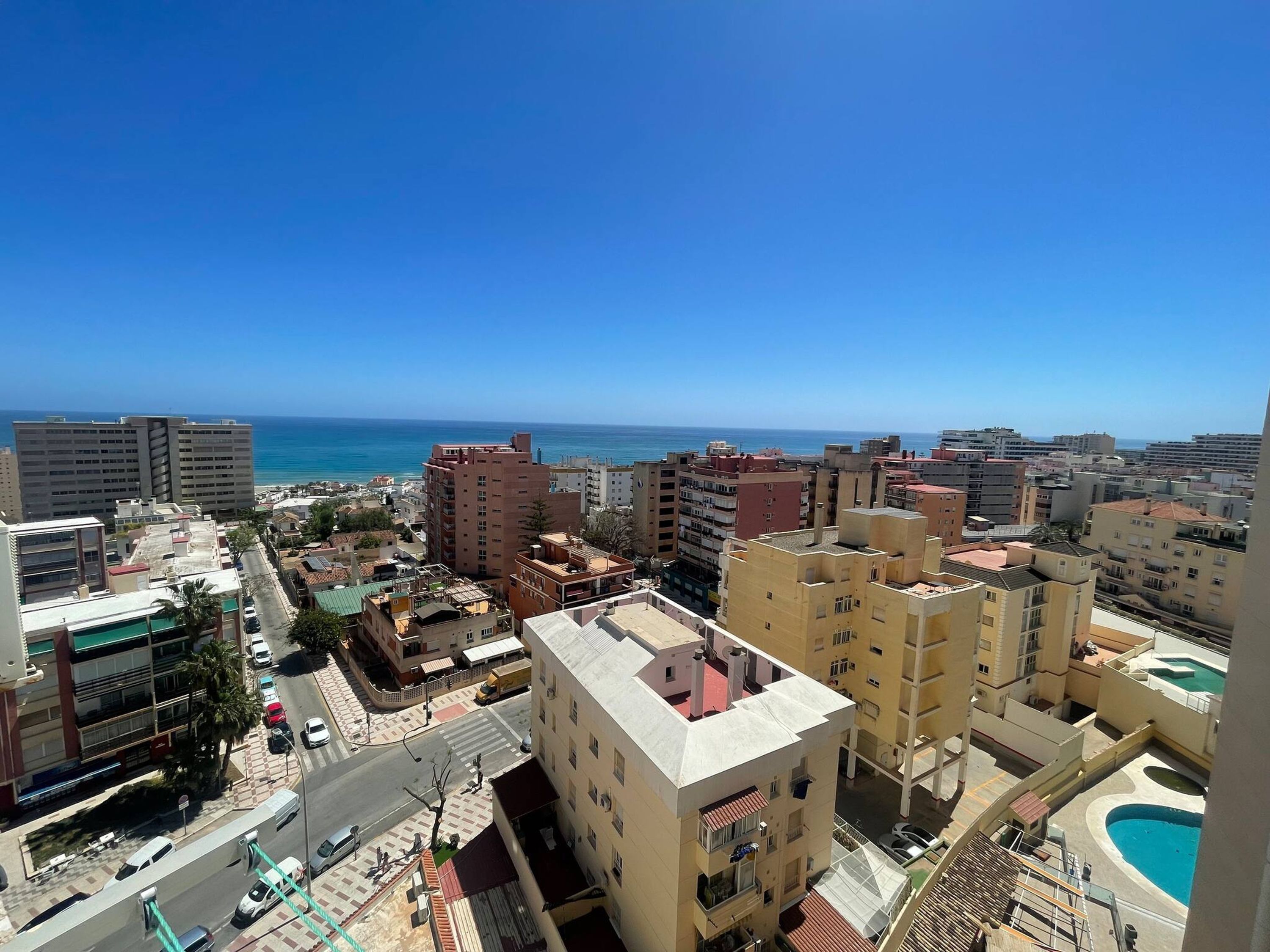 Um edifício alto com várias varandas e uma piscina.