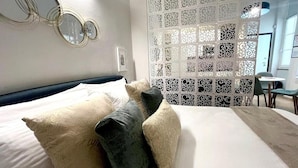 Cama bem arrumada com várias almofadas em quarto de hotel moderno.
