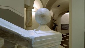 Escadaria com balaustrada e uma esfera de mármore na balaustrada.