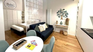 Uma sala de estar moderna com sofá, mesa de centro e parede decorada com árvores.