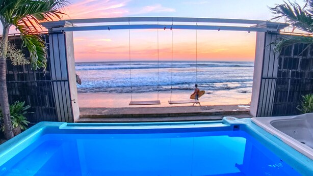 Piscina com vista para o oceano e um balanço.