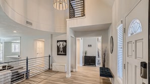 Um interior espaçoso com piso de madeira, escada e um banco.
