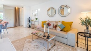 Uma sala de estar moderna com sofá, mesa de centro e espelhos decorativos.