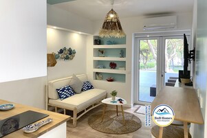 Uma sala de estar moderna com um sofá, uma mesa redonda e estantes com objetos decorativos.