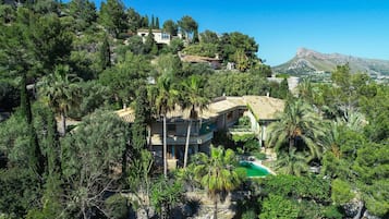 Uma villa rodeada por vegetação exuberante e uma paisagem montanhosa.
