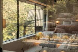 Um quarto com uma janela grande, uma cama e um sofá.