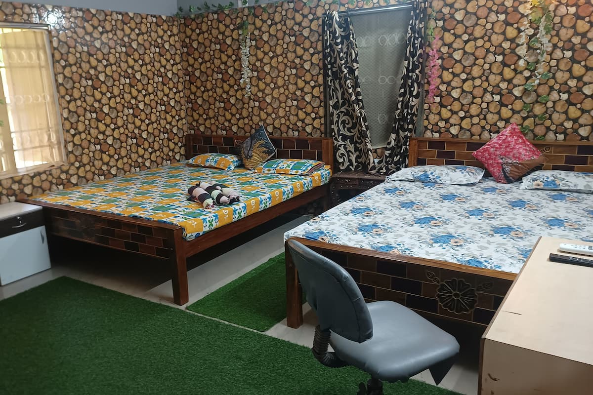 Quarto com duas camas, uma mesa e uma cadeira.