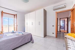 Quarto com cama, guarda-roupa e ar condicionado.