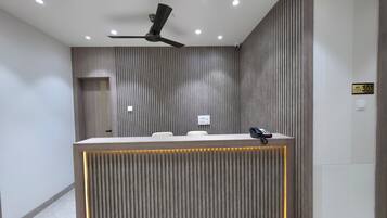 Uma receção com design moderno, um ventilador de teto e iluminação embutida.