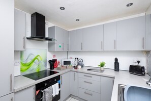 Um frigorífico, um micro-ondas, um forno, uma placa de cozinha