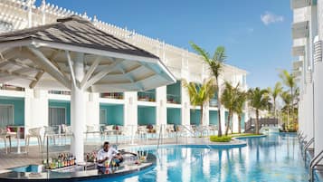 Uma área de bar à beira da piscina, com um bartender, espreguiçadeiras e piscina.