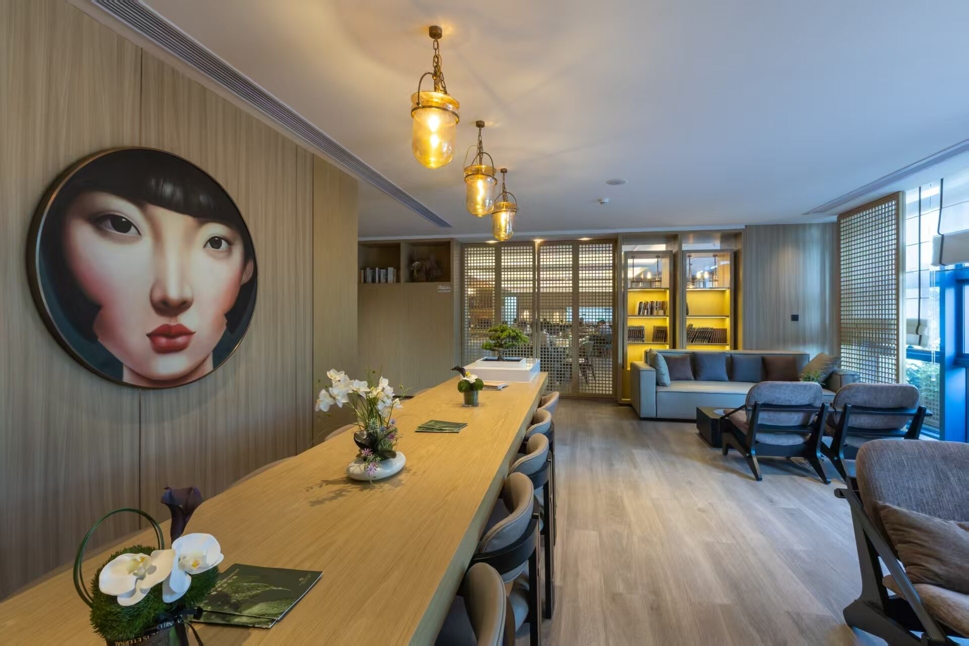 Uma sala de estar moderna com uma mesa de jantar de madeira, assentos confortáveis e uma grande obra de arte na parede.