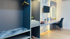 Quarto moderno com uma cama, escrivaninha, cadeira e espelho.