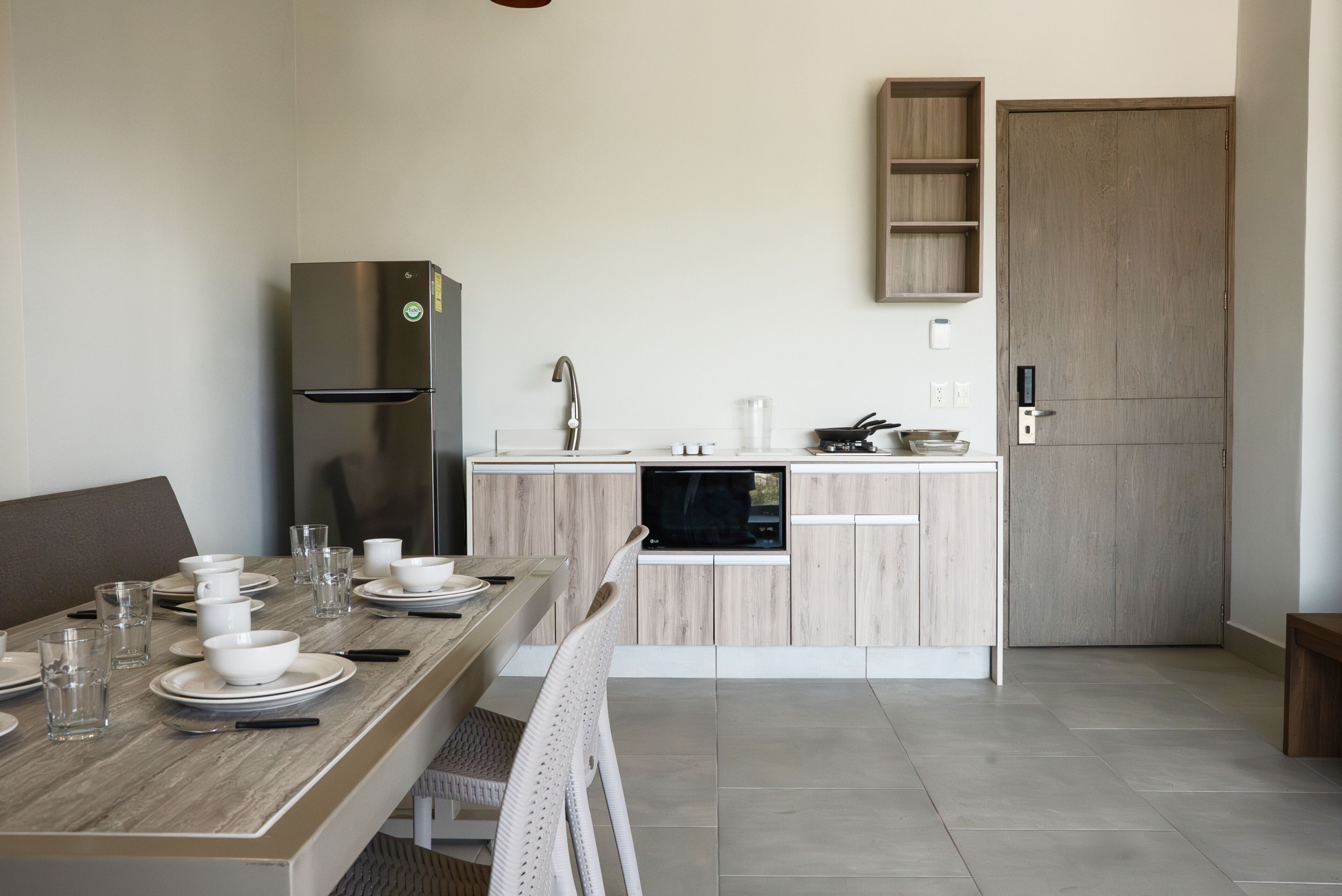 Uma cozinha moderna com frigorífico embutido, micro-ondas e um armário de madeira.
