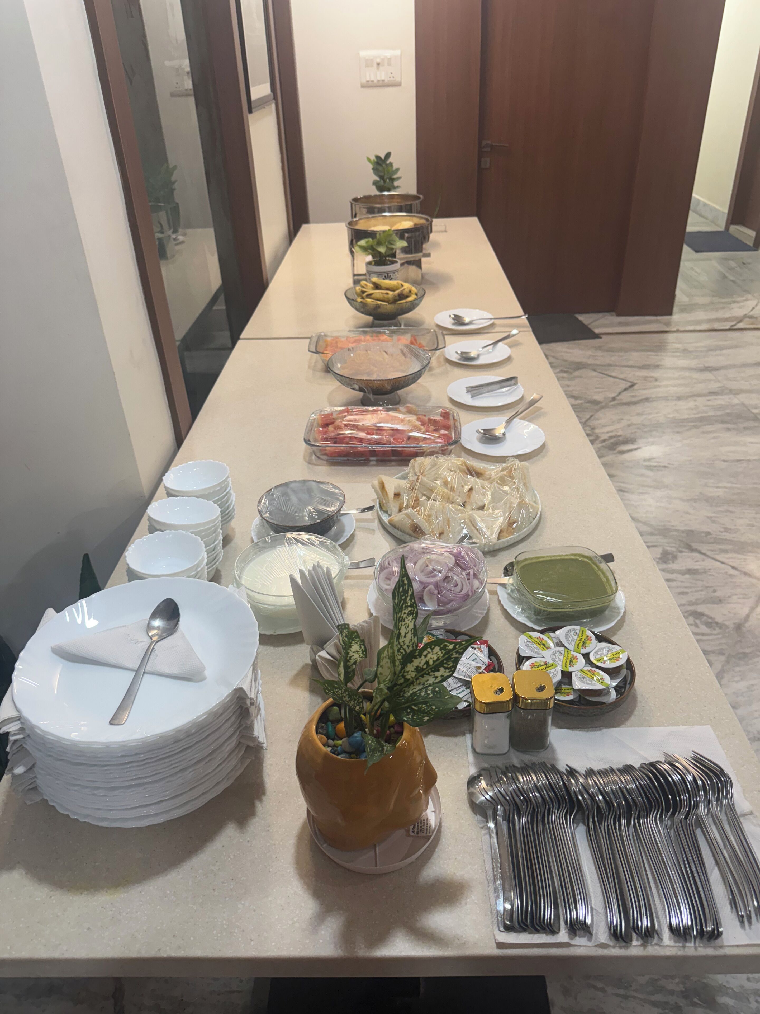 Uma mesa de buffet com diversos alimentos e utensílios.